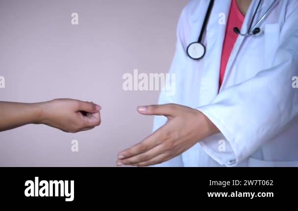 Female doctor hand checking the pulse rate of a young patient at a ...