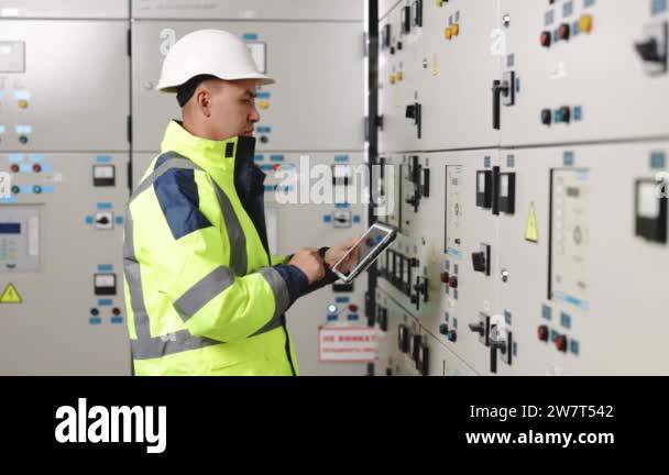 Asian man electrical engineer hold tablet monitoring electrical system ...