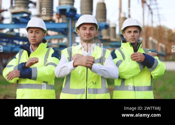 Portrait of group of professional electric industry engineers crossing ...