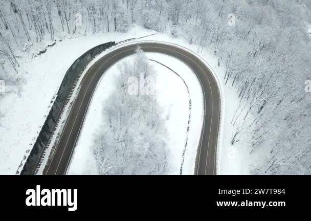 Drones Eye View - winding road from the high mountain pass in winter. Great road trip trough the ...