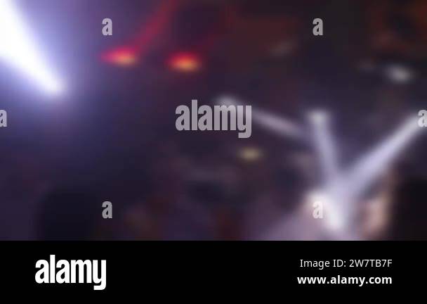 Neon lights on the dance floor. Slow time. Blurry bokeh. People are ...