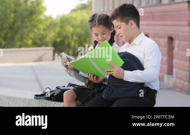 Two children schoolchildren students pupils little girl and small boy ...