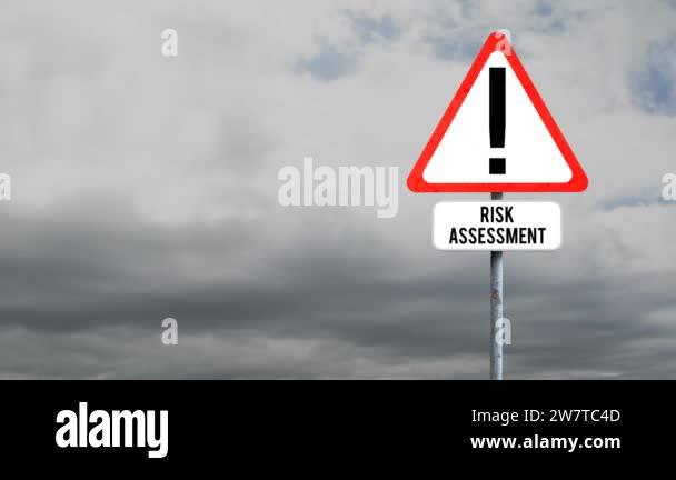 Attention signboard post with risk assessment text against dark clouds ...