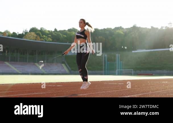 Female athlete jumping in jumping rope. Attractive woman jump roping on ...