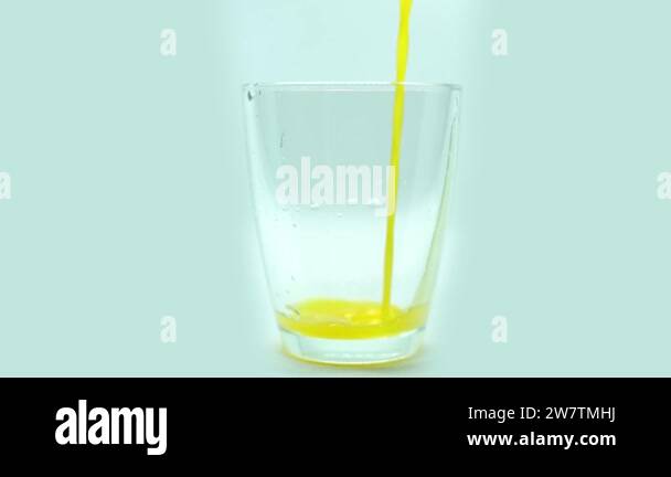 Slow motion of orange juice pour in a transparent glass isolated on ...