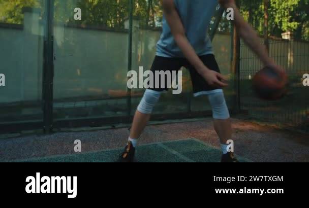 Male basketball player dribbling ball scoring hoop fast during training ...