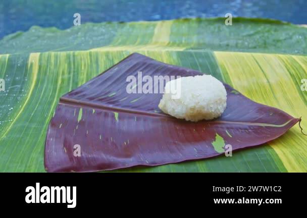 Mango sticky rice served on a spotted banana leaf by the pool.speckled ...