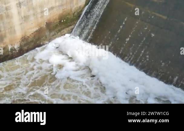 Closeup release of water from the dam. Aerial view of water flowing ...
