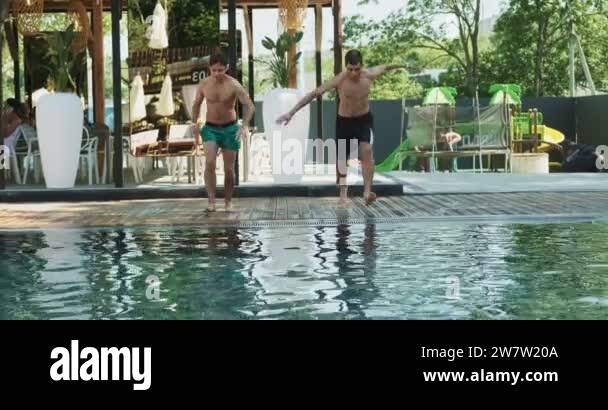Friends jumping in the swimming pool underwater and having fun ...