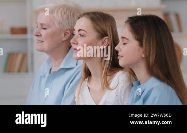 Profile side faces view three gen women pose in living room. Smiling ...