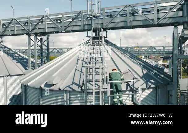 Engineer servicing and inspecting large grain storage containers. An ...