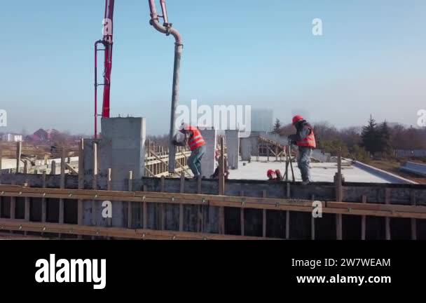 Aerial of concrete boom pump crane arm truck with outriggers pouring ...