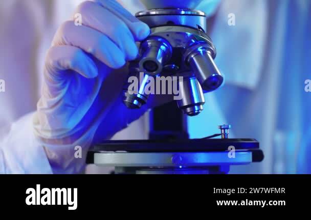Professional scientist looks through microscope studying new types ...