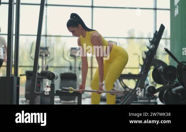 Hispanic woman performing barbell bent over row. Fitness woman training ...