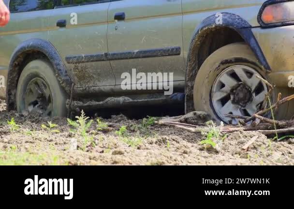 SUV 4WD car stuck in muddy off-road. Closeup the wheel rotates in the ...