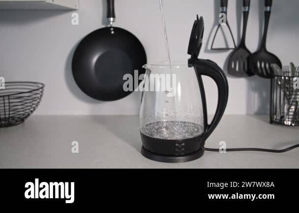 household, clean cool water is poured into a transparent electric ...