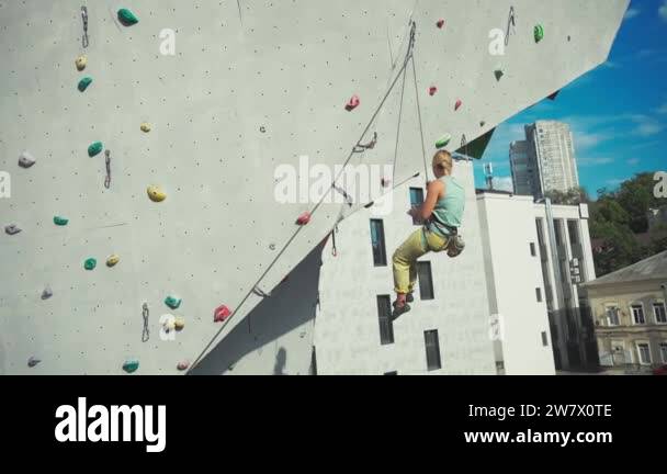 young girl rock climber hanging on rope after falling from route on ...