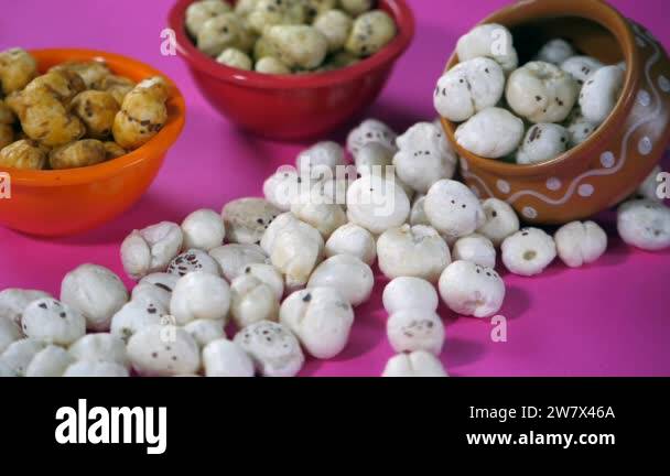 A few white fox nuts / Makhana falling on a heap beautifully placed on ...