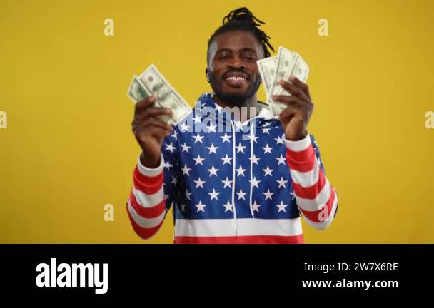 Excited rich African American smiling man dancing at yellow background ...
