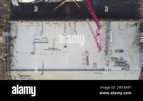 Aerial of concrete boom pump crane arm truck with outriggers pouring ...