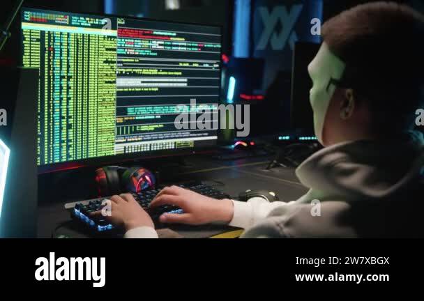A masked hacker breaks into a database on a computer, hacking in a dark room Stock Video Footage ...