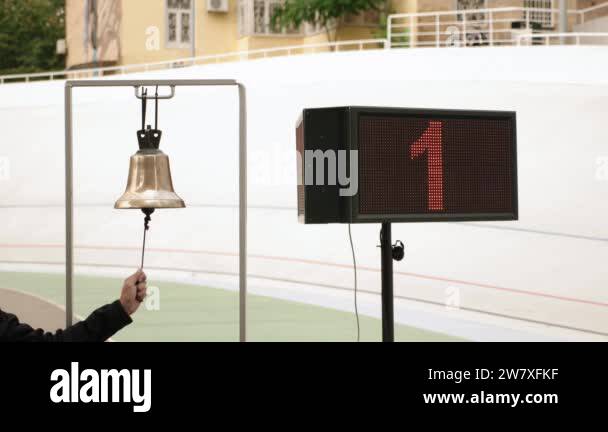 Cycling referee ring bell on finish circle on track bike race ...