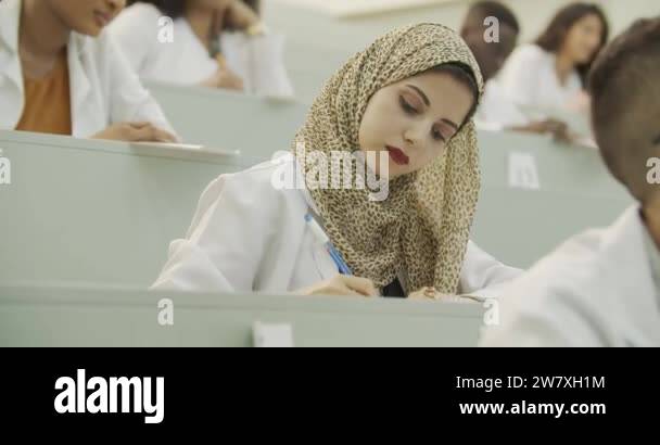 Muslim female student. A Muslim young woman in a hijab sits at a ...