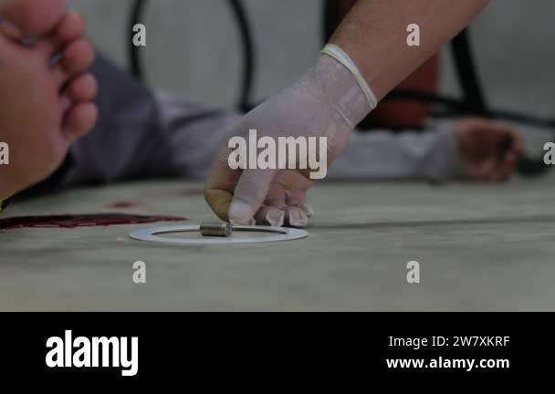 forensic inspector highlighting the shells of a gun at the crime scene ...