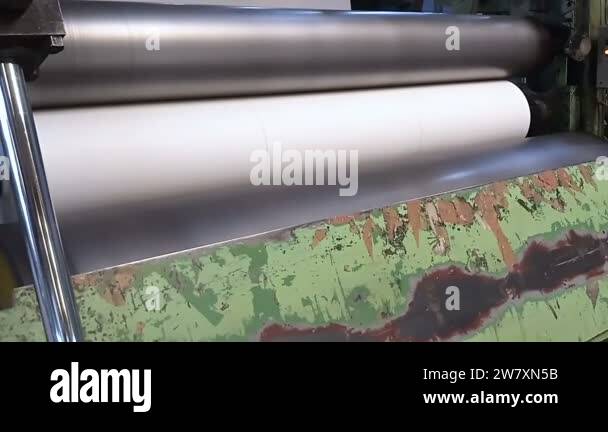 A modern four colour printing machine running white paper through ...