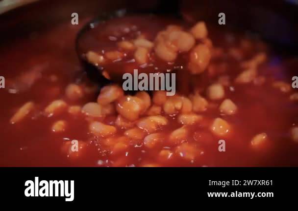 Ladle stirring delicious traditional Mexican pozole in cooking pot ...