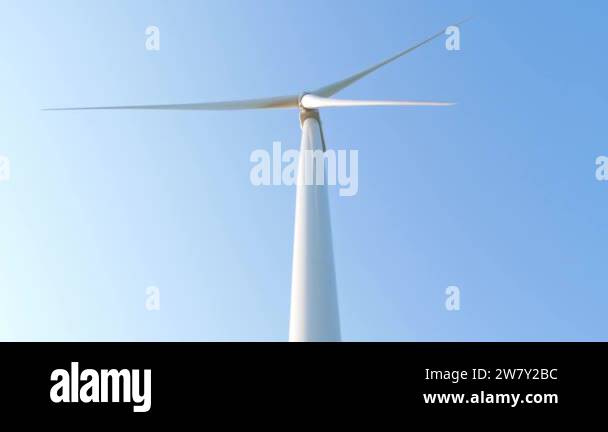 Wind turbine rotating on clear blue sky background. Local eco friendly ...