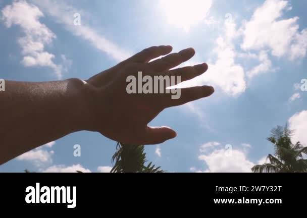 Hot summer sunlight rays pouring through human hand. Hand covering sun ...