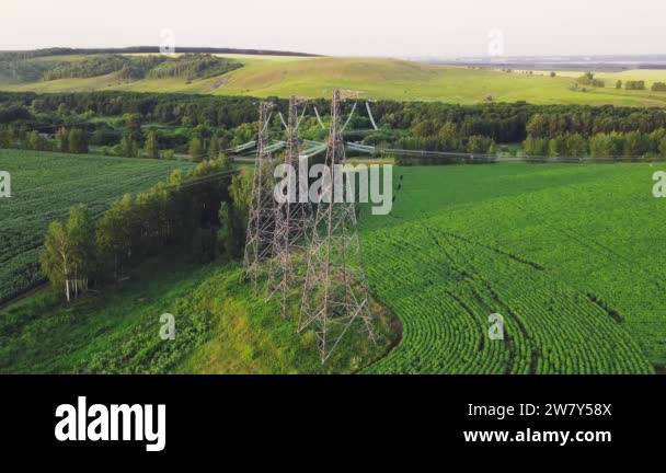 Transmission line in rural field. High-voltage tower for electrical ...