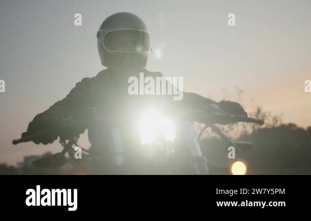 A motorbike rider with his helmet on ready to have a ride looking back ...