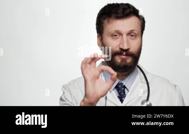 Doctor OK. Portrait of positive smiling man doctor on white background ...