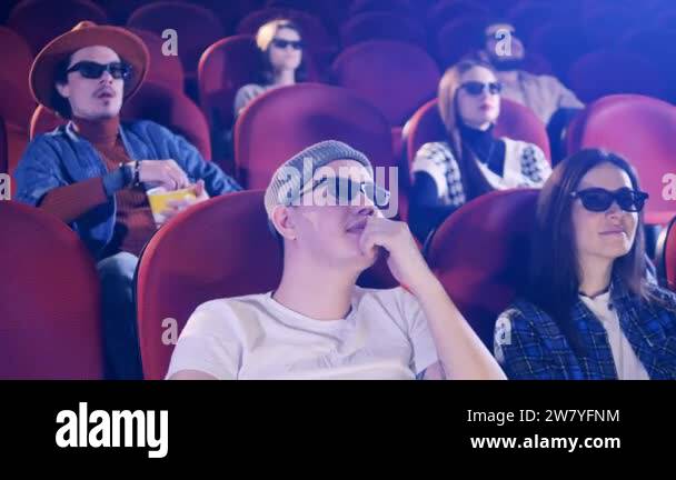 Rude man puts his feet up and throws popcorn at the movie theater Stock ...