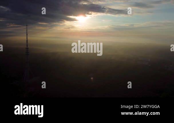 Sunrise loop aerial view on tv tower dark silhouette in forest with ...