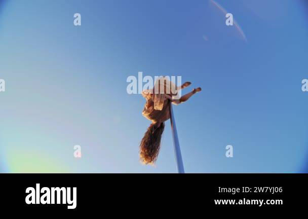 pole dance. fit female gymnast, in beige leotard, performs acrobatic ...