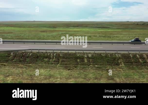 Cars are driving on a modern multi-lane highway against the background ...