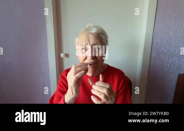 Dental concept. Elderly female 90 years old inserts denture. Senior ...