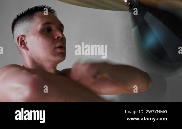Boxing training - young man punching a small punching bag in front of ...
