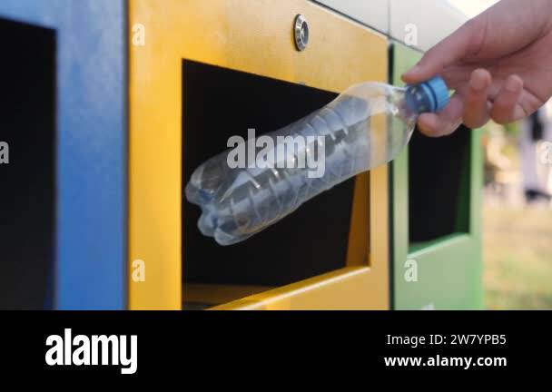 Empty bottle. Plastic garbage bin trash container. Hand bottle into ...