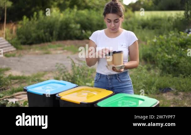 Female throwing out in the recycling bin disposable cup. Woman separate ...