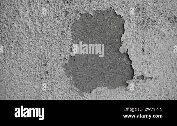 White damp wall showing paint cracking open and breaking or peeling off ...