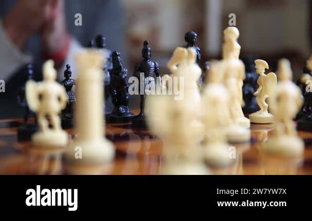 Chess white and black pieces fight on battlefield for their king. Hand ...