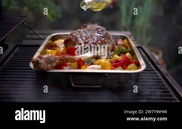 Chef cooking a delicious leg of lamb on barbecue with colors peppers ...