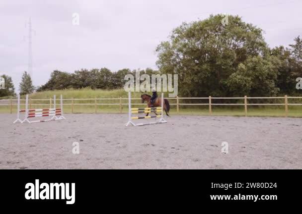 Woman Riding Horse In Paddock With Horse Jumping Fences Stock Video ...