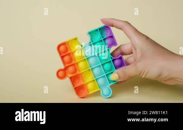 Popular modern rainbow-colored popit toy in the form of a puzzle in ...