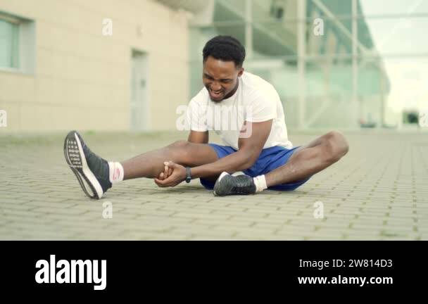 young african american runner athlete with muscle pain. Man massaging ...