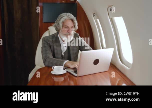 Excited mature male looks at laptop and rejoices in victory while ...